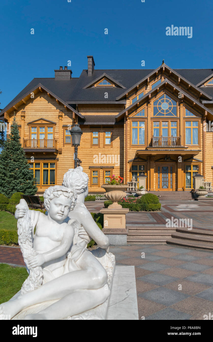 charming gypsum sculpture in a park with a modern house with log walls ...
