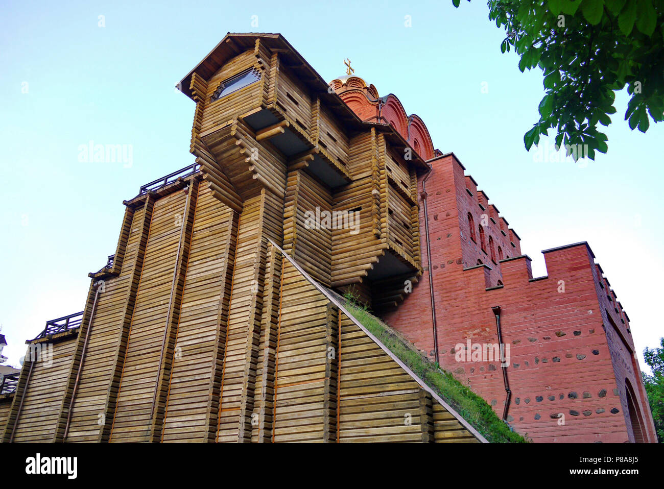 A tall ancient temple of red brick in one half and a wooden building on ...