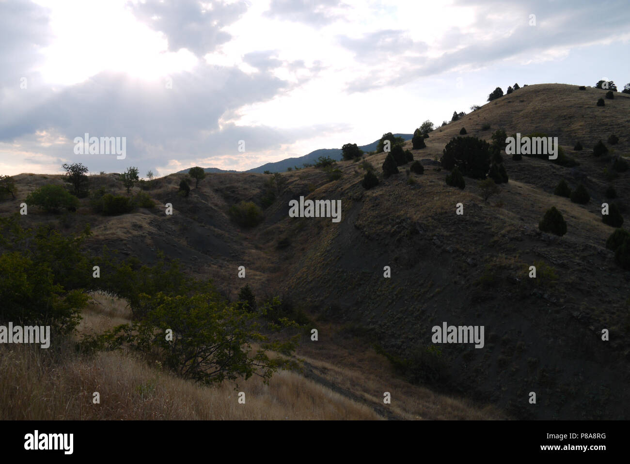 the sun in the sky is visible on a small depression on a mountain slope ...