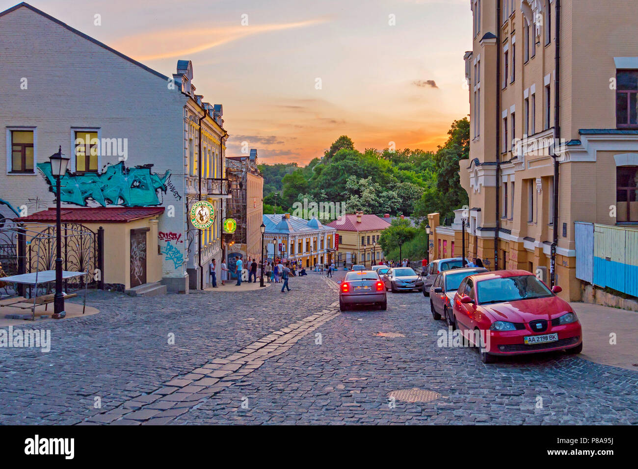 The wide street lined by a pavement goes down downtown Uzhgorod. Many ...