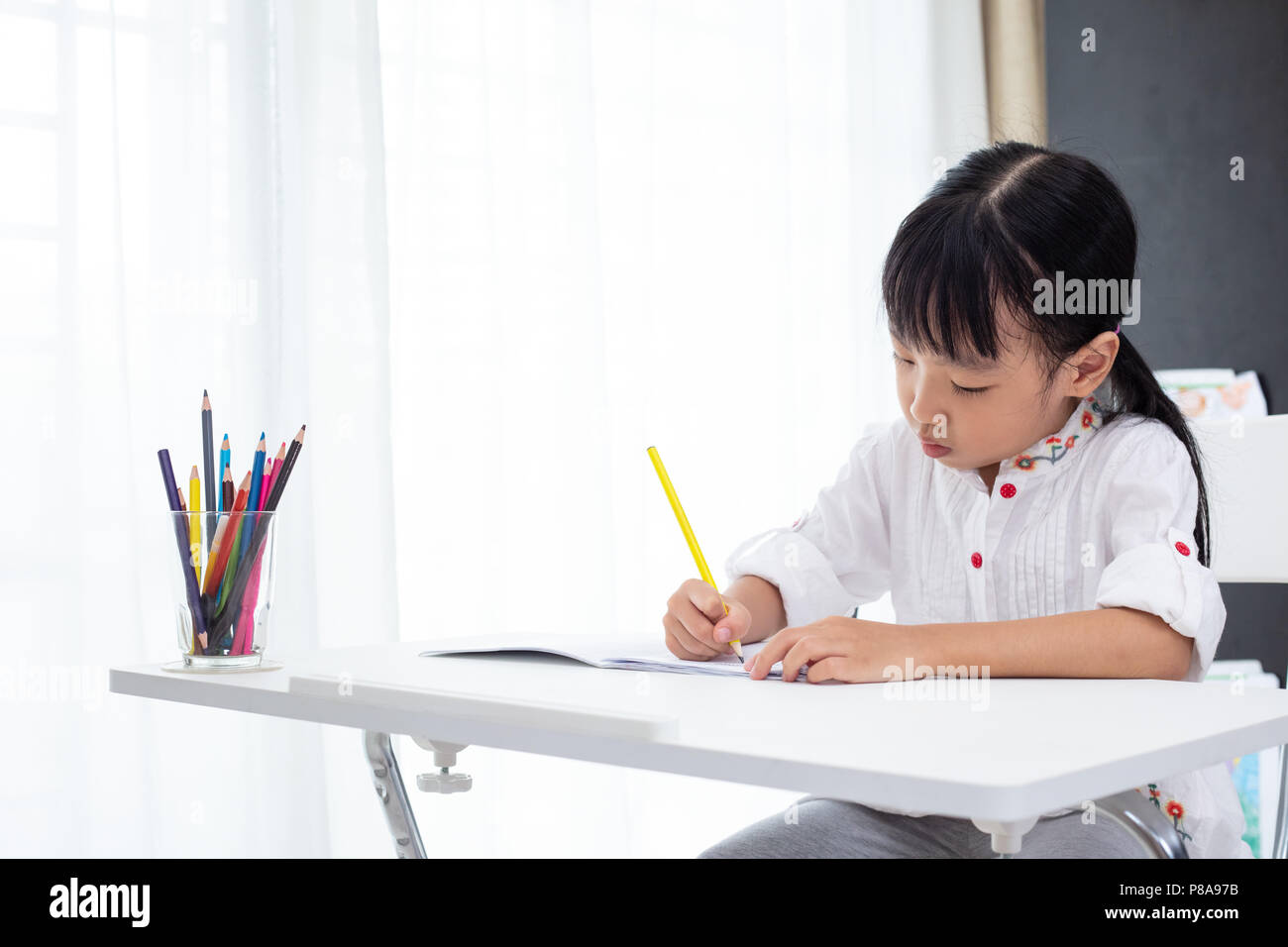 Asian Little Chinese girl doing homework at home Stock Photo - Alamy