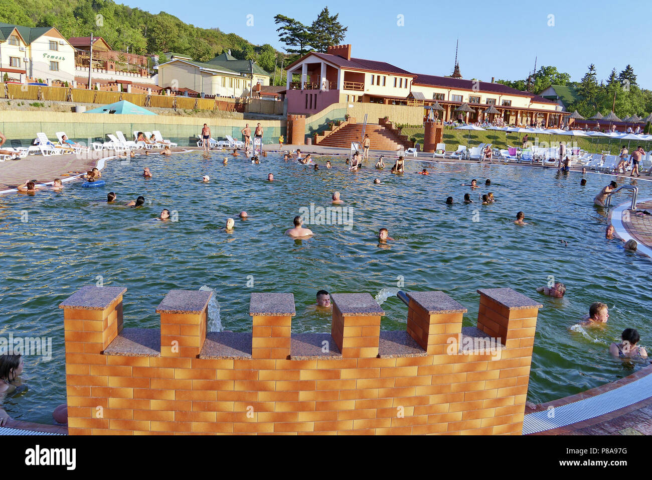 A small pool with blue water, fenced with fences in the form of a chess ...