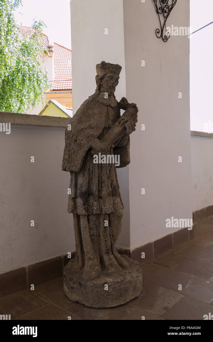 High stone statue in the spacious corridor of a medieval old castle ...