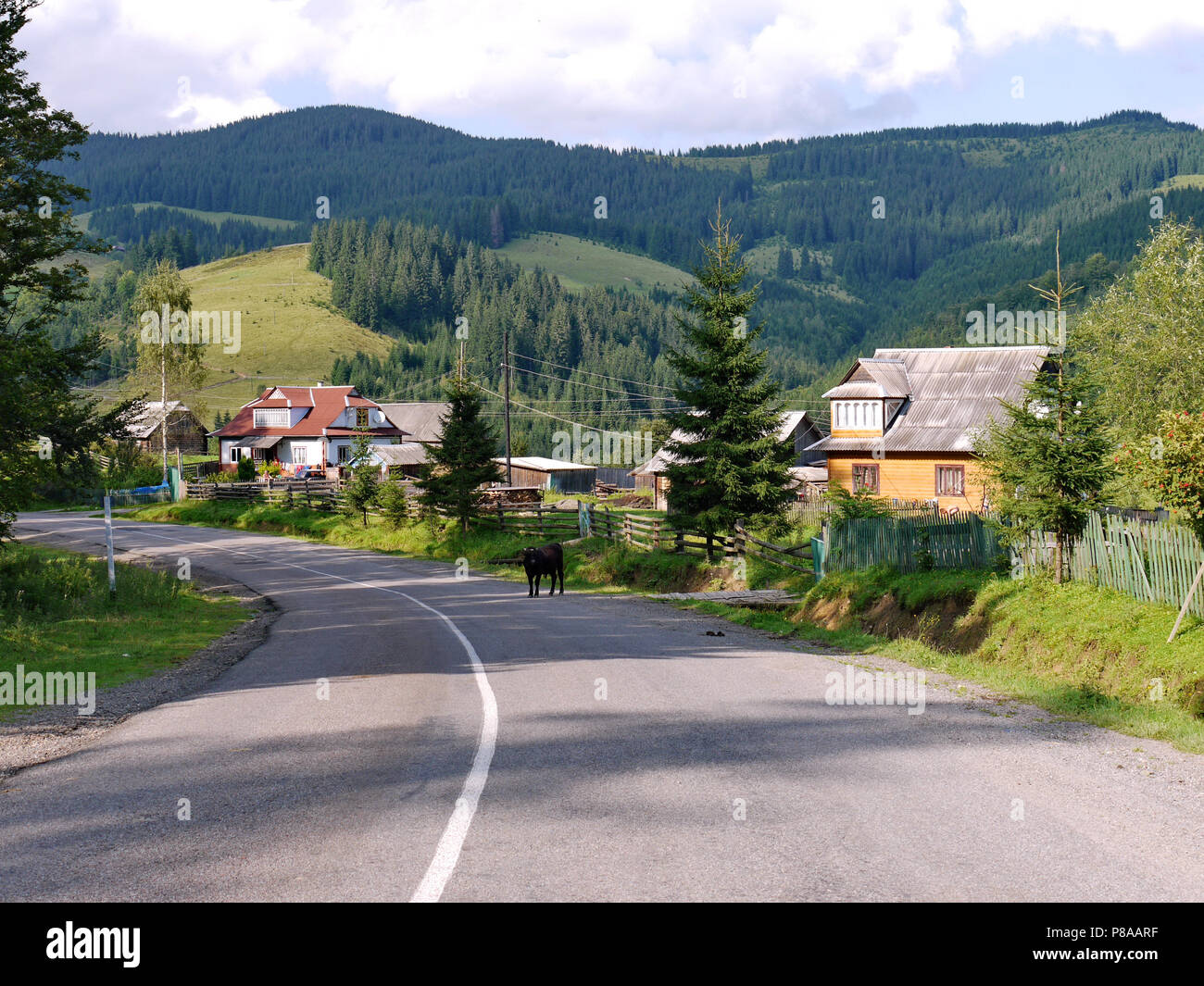A steep road with rustic houses on each side and a beautiful view of ...