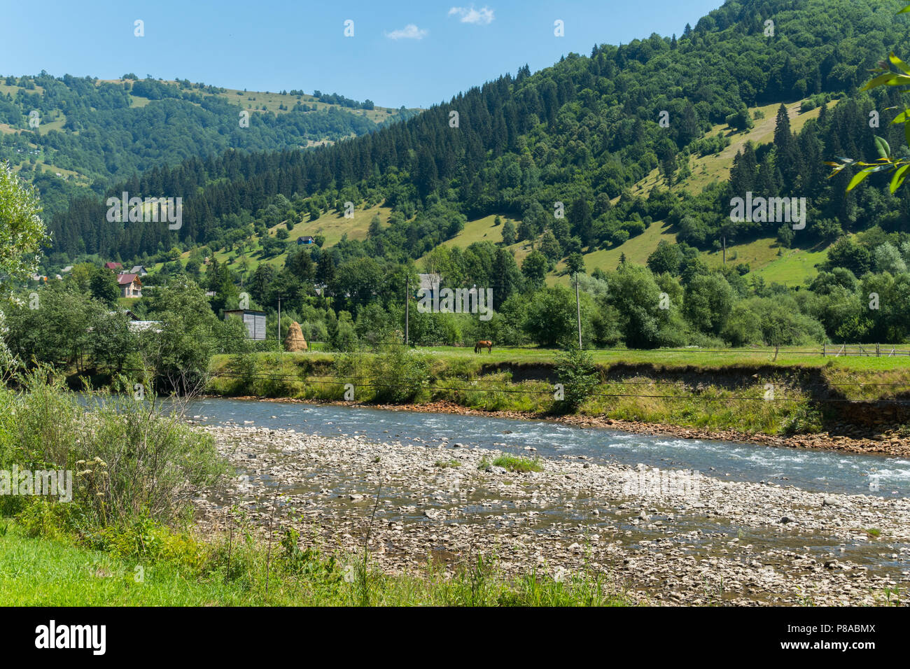 A beautiful, natural mountain landscape with river, trees and mountains ...