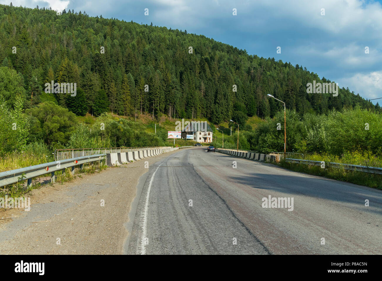 Asphalted road with a parapet on the road leads to a mountain where ...
