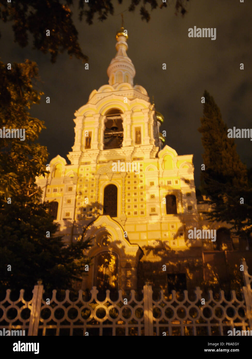 The white church is flooded with bright sun rays from one side and ...