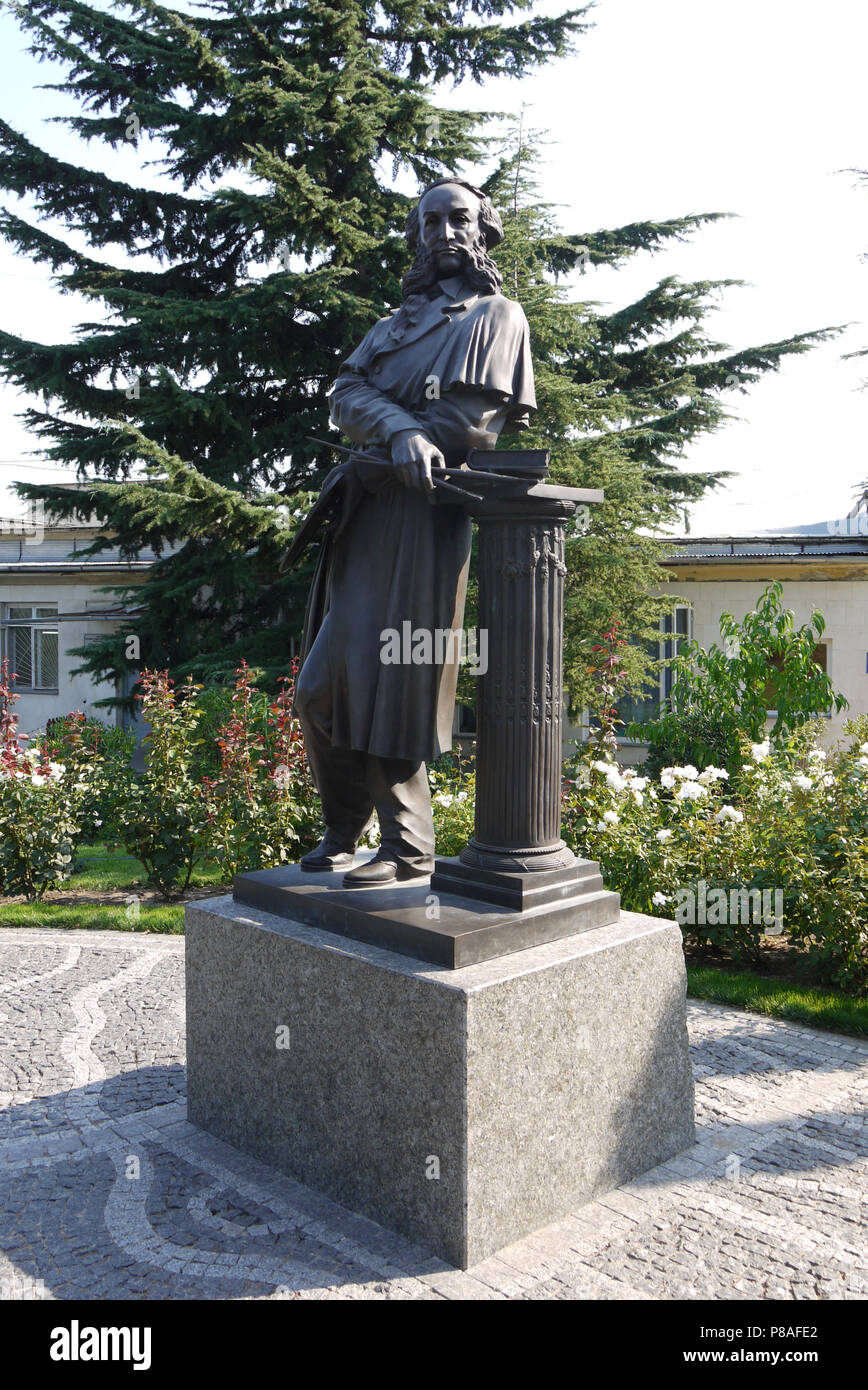A monument with a standing man leaning on a column with large sideburns ...