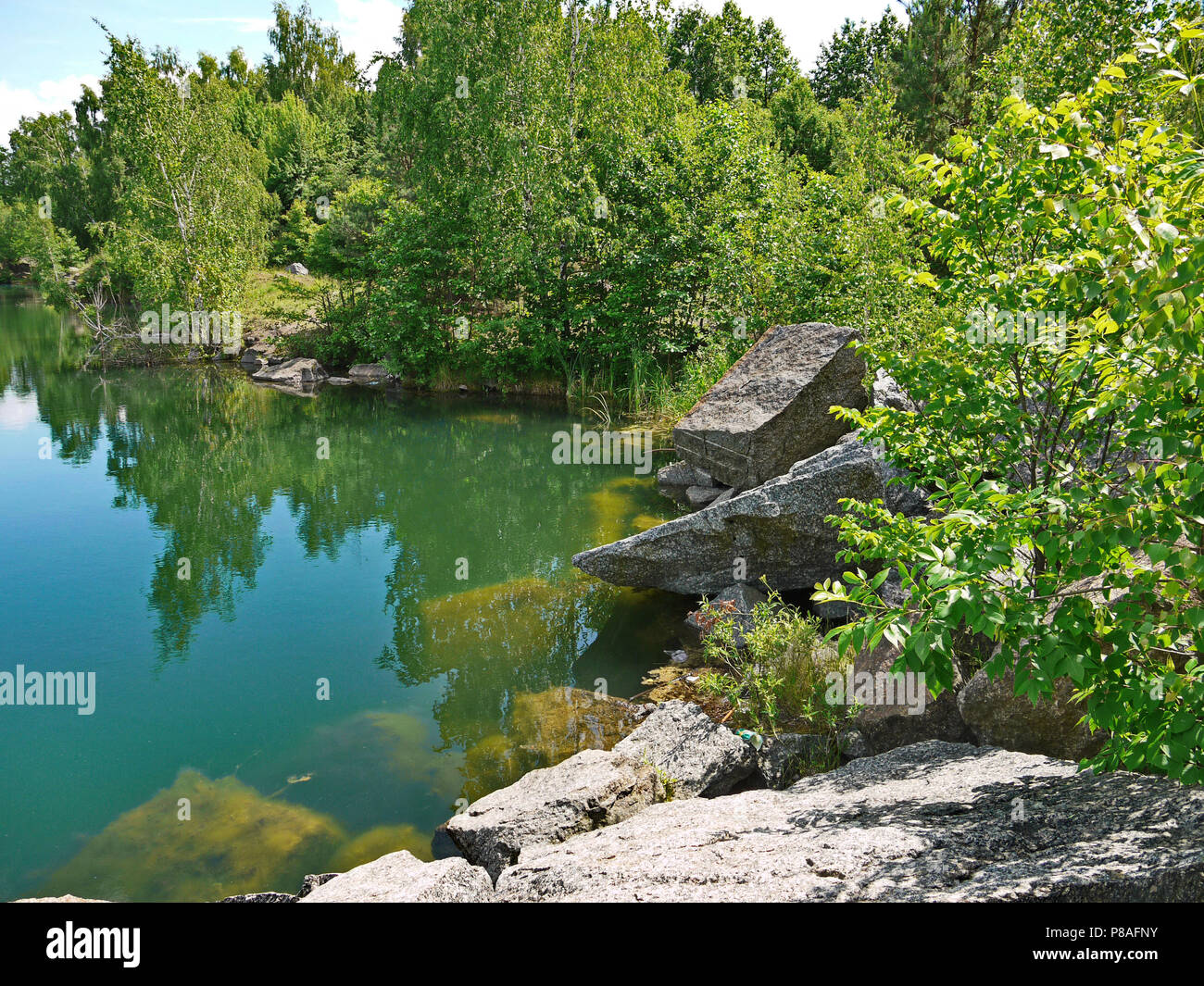 Rocky coast with large stone boulders at the transparent deep blue ...