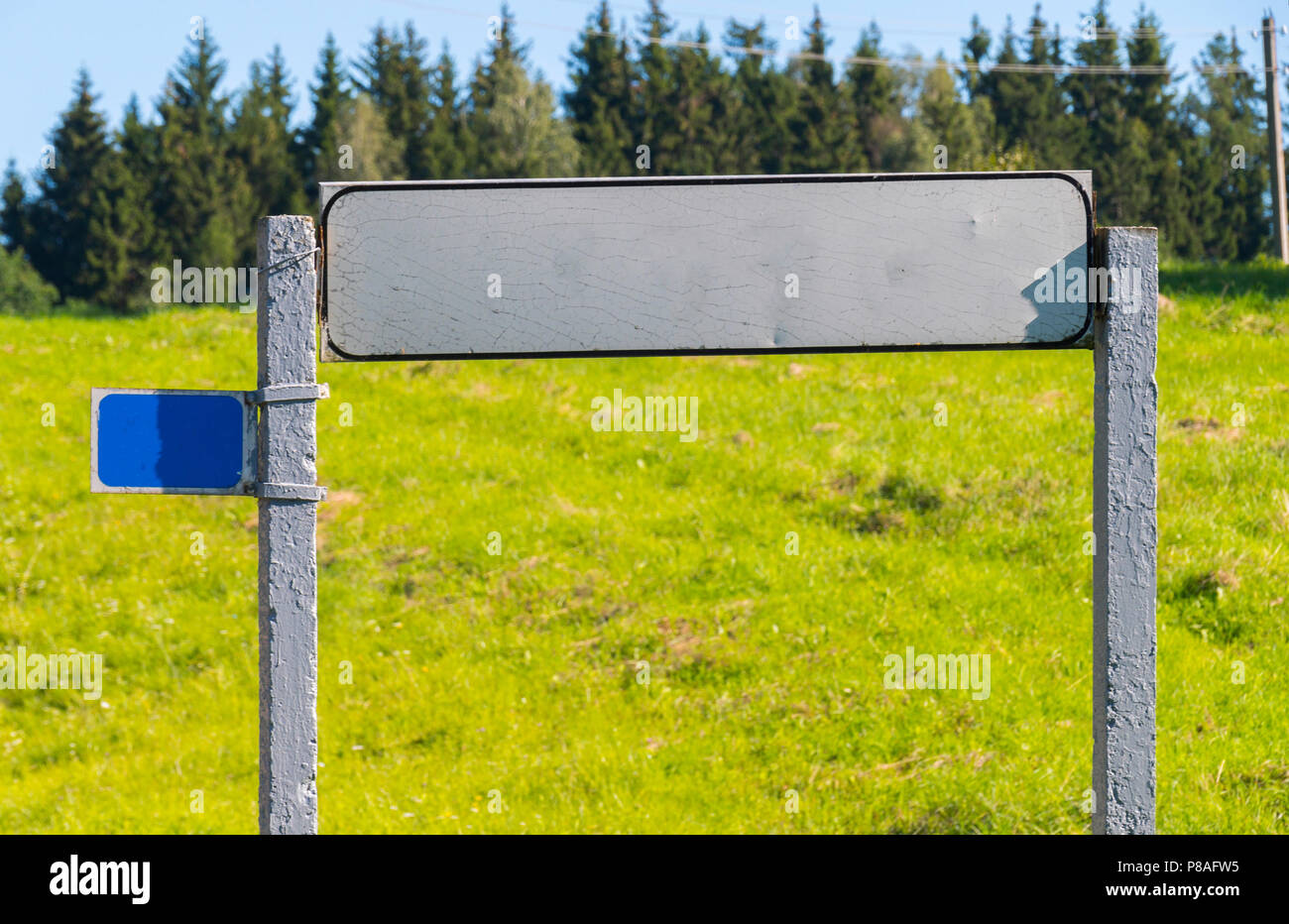 Rectangular road sign from the back side against a background of green ...