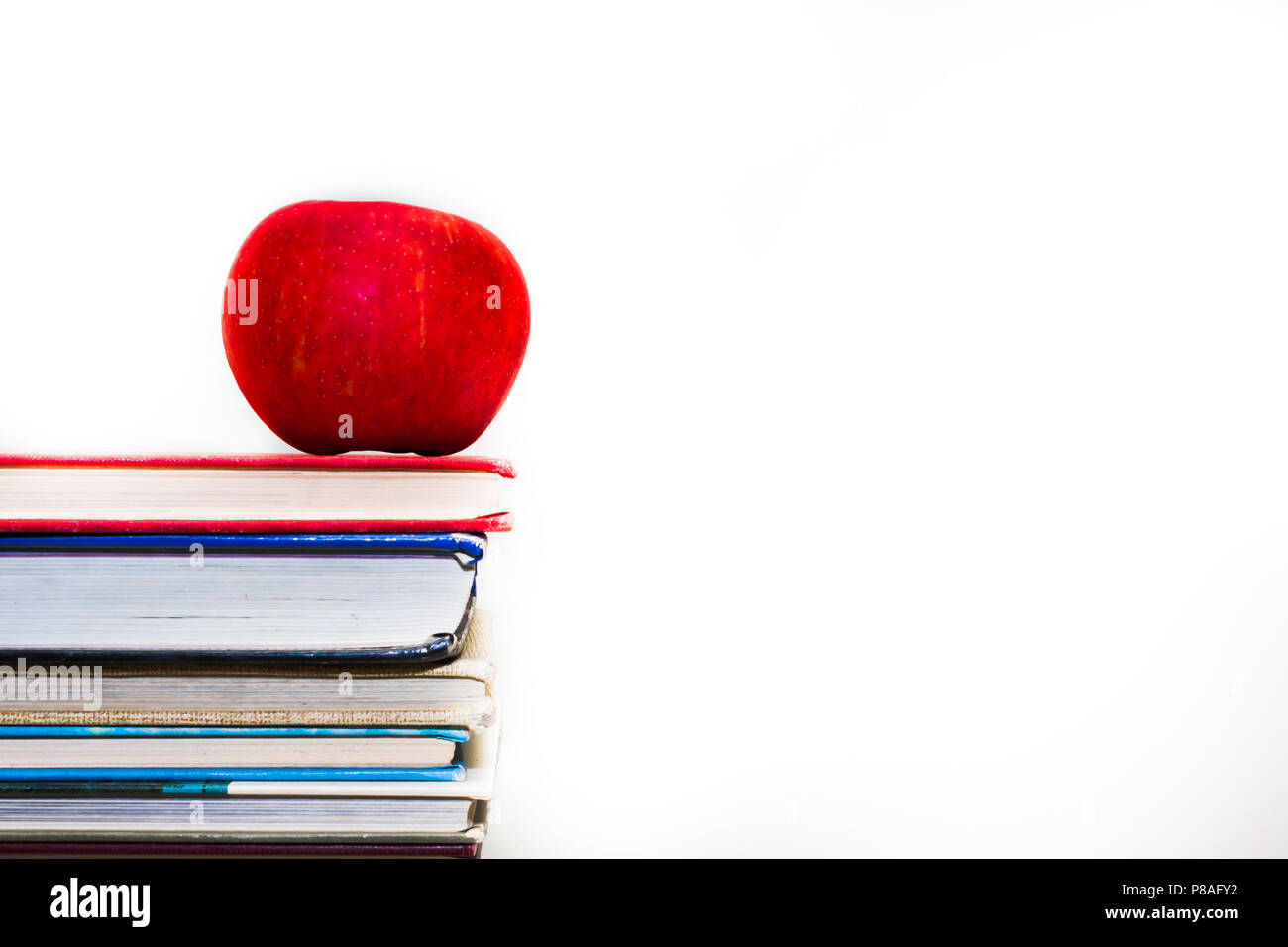 Stack of books with a single red apple on top Stock Photo - Alamy