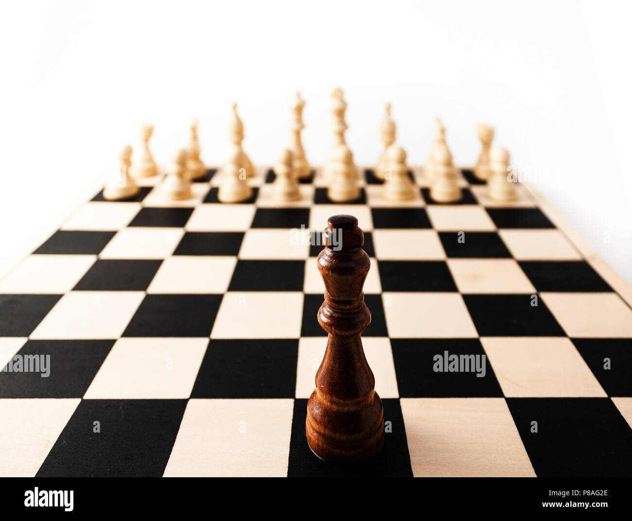 Black chess piece with a stretched perspective alone up against many ...