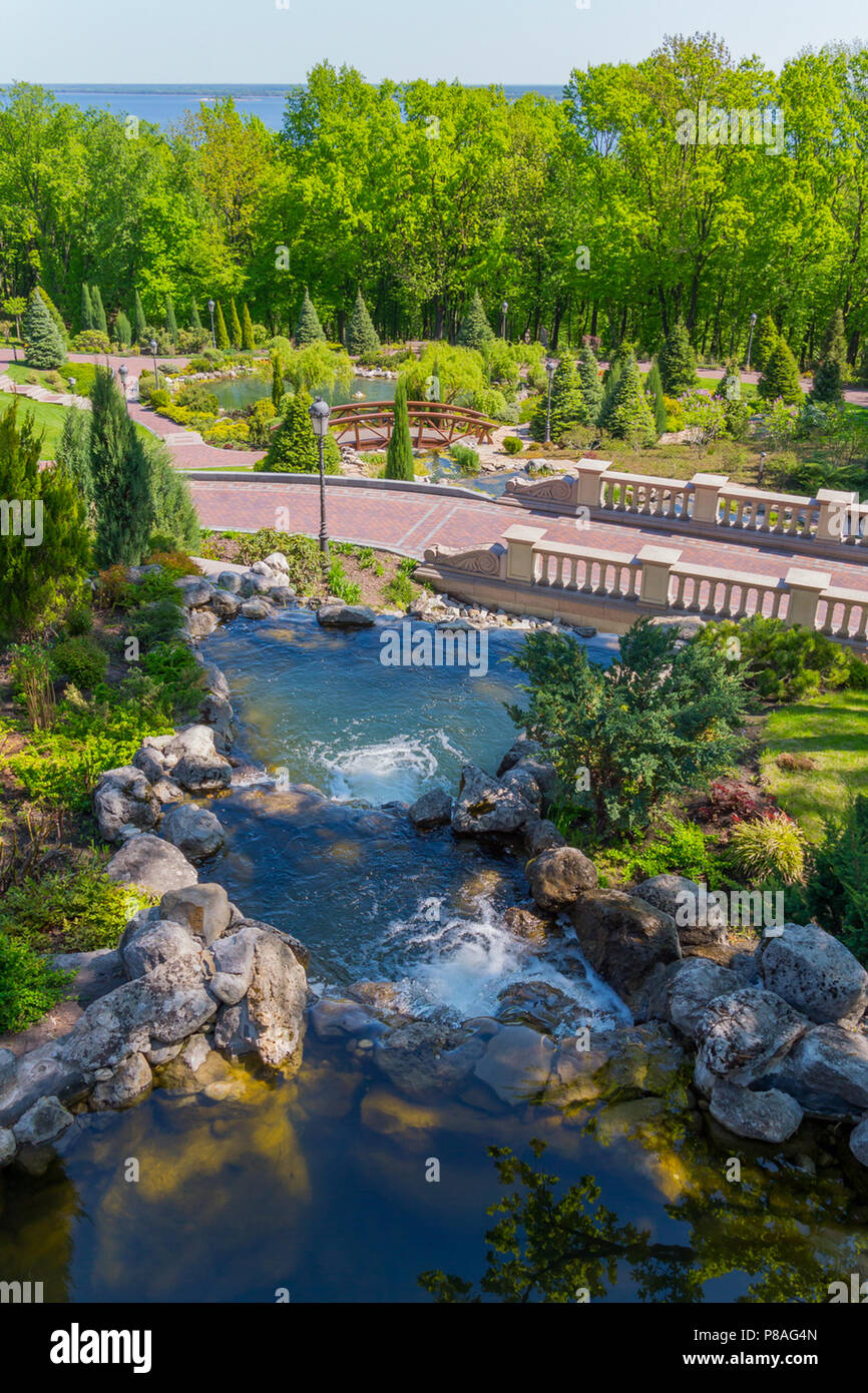 Decorative cascading waterfall, passing under two small bridges and ...