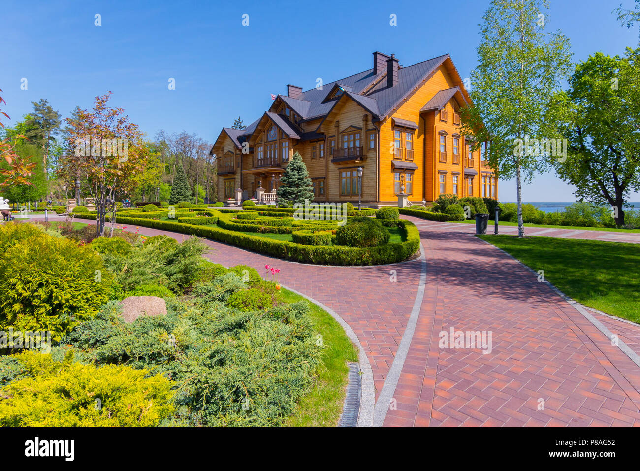 red stone path to a wooden house with a beautiful garden landscape ...