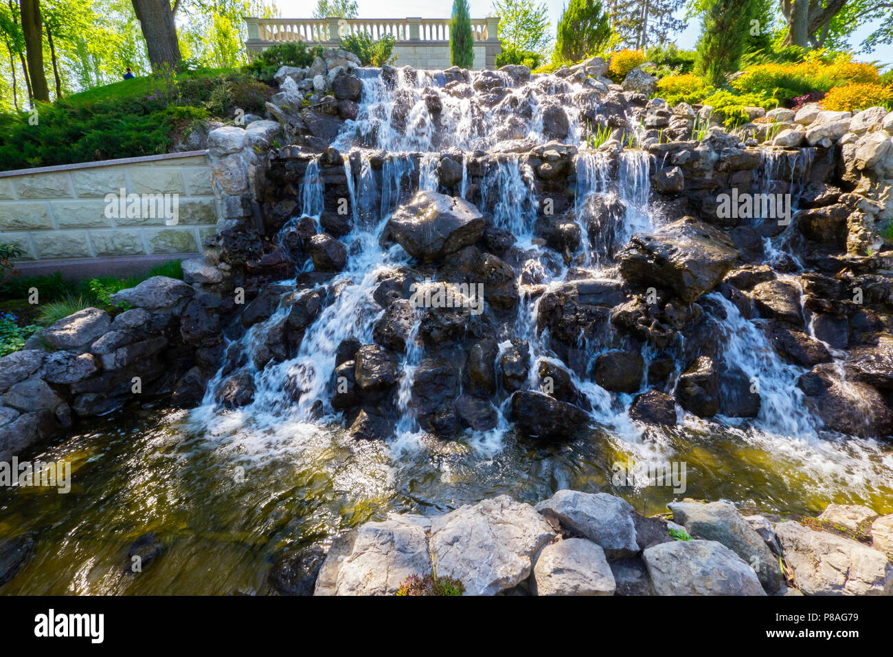 transparent water stream running down the rocks in the park . For your ...