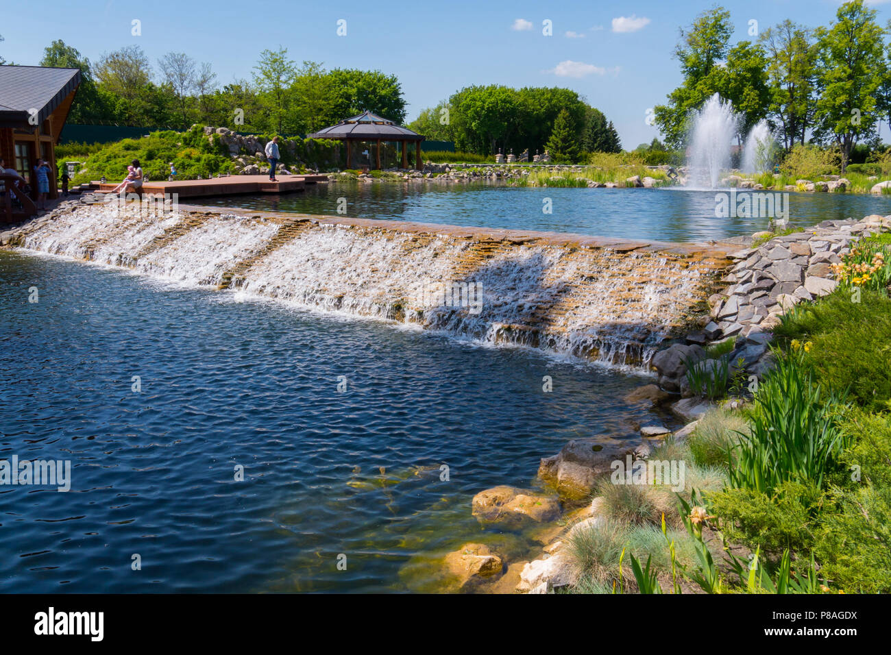 two-tiered pond with flowing water over the edge. On the beach there ...