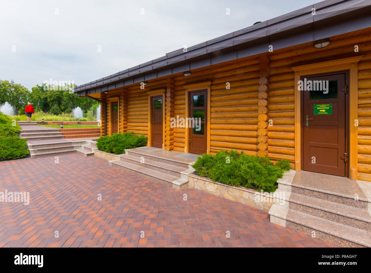 elegantly made neat building of logs and an ideally paved area in front ...