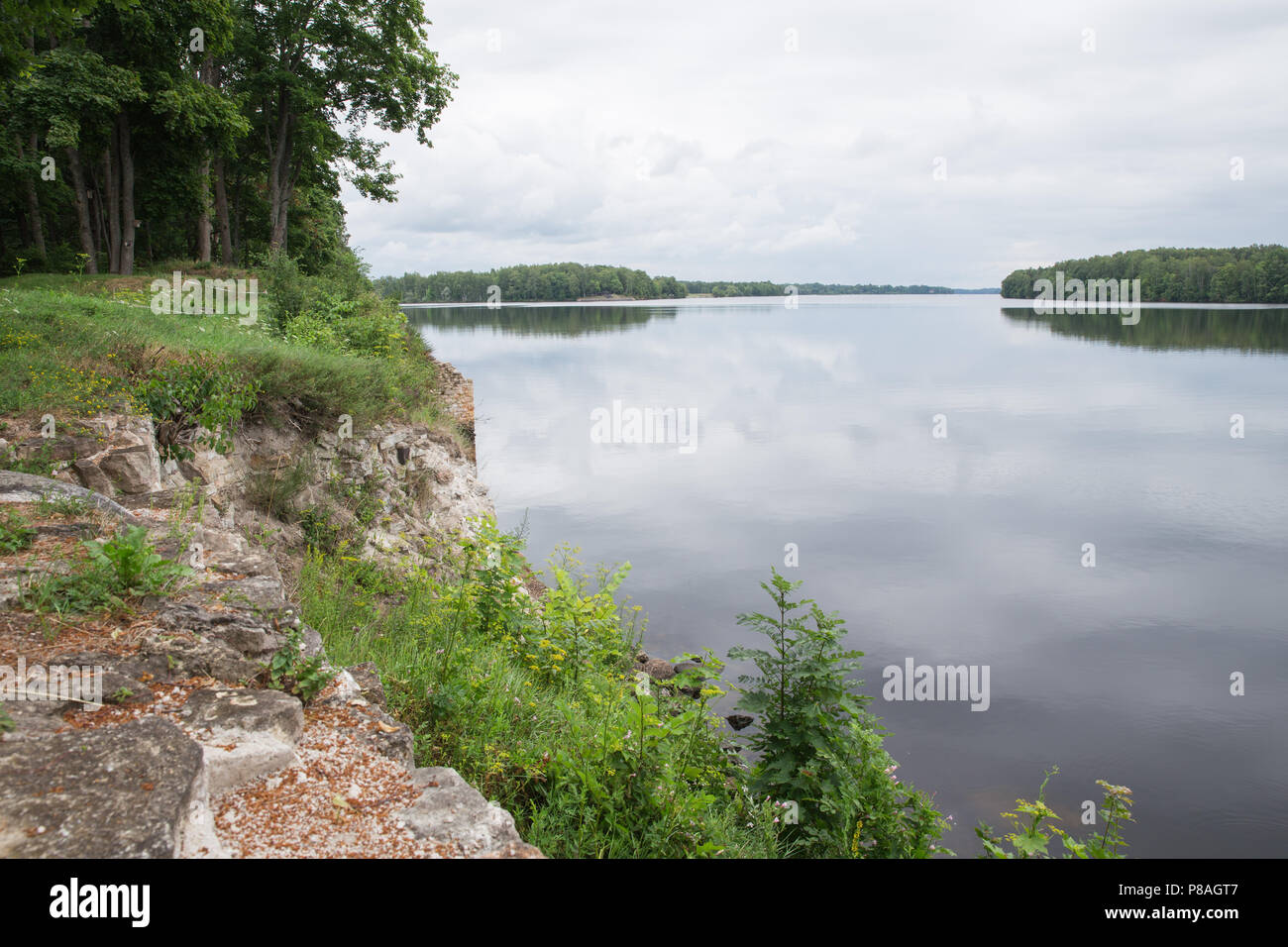 City Koknese, Latvia. Old river and green trees. Ruins and reflection ...