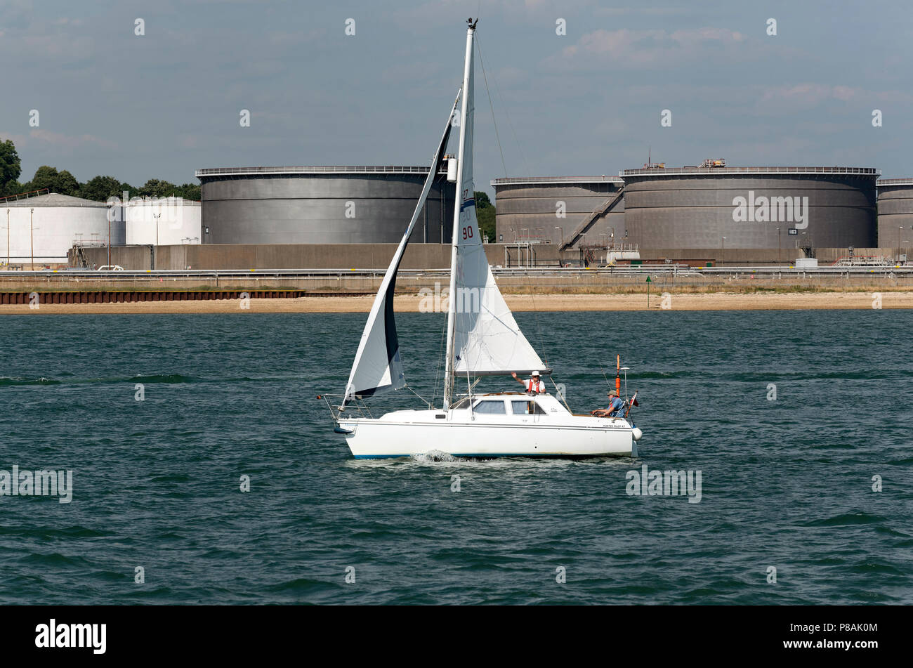 A Hunter Pilot 27 yacht with two crew passing BP Hamble Oil Terminal at ...