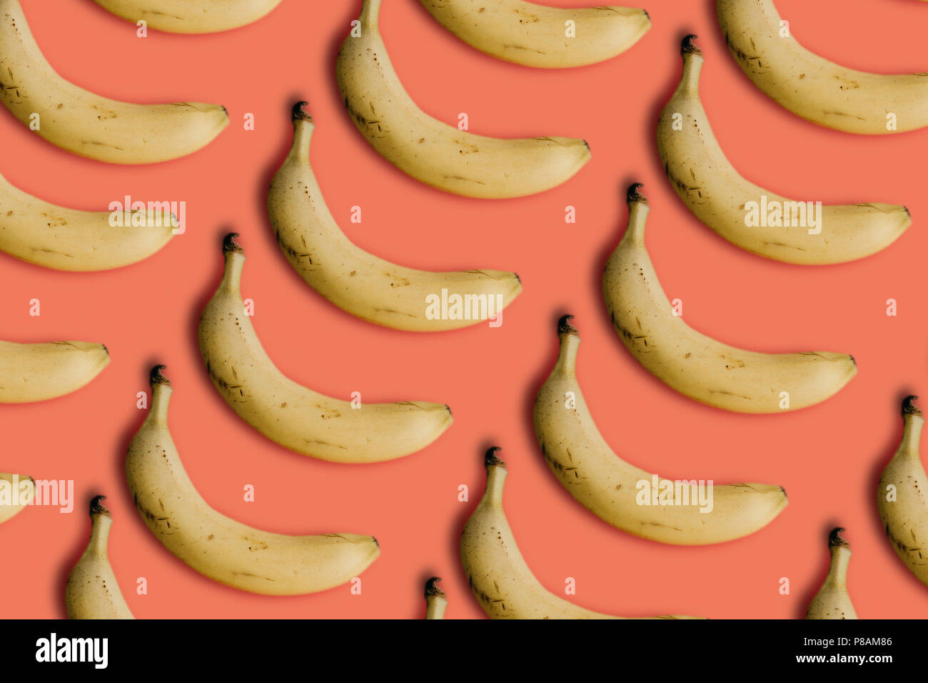 Many bananas in a row on a pink background Stock Photo - Alamy