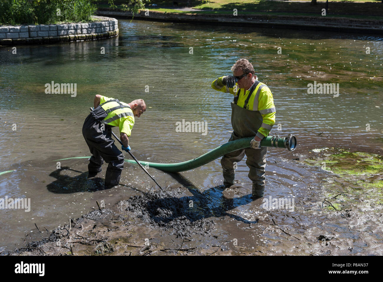 Workers using a suction pump to remove mud and silt in a lake Stock ...