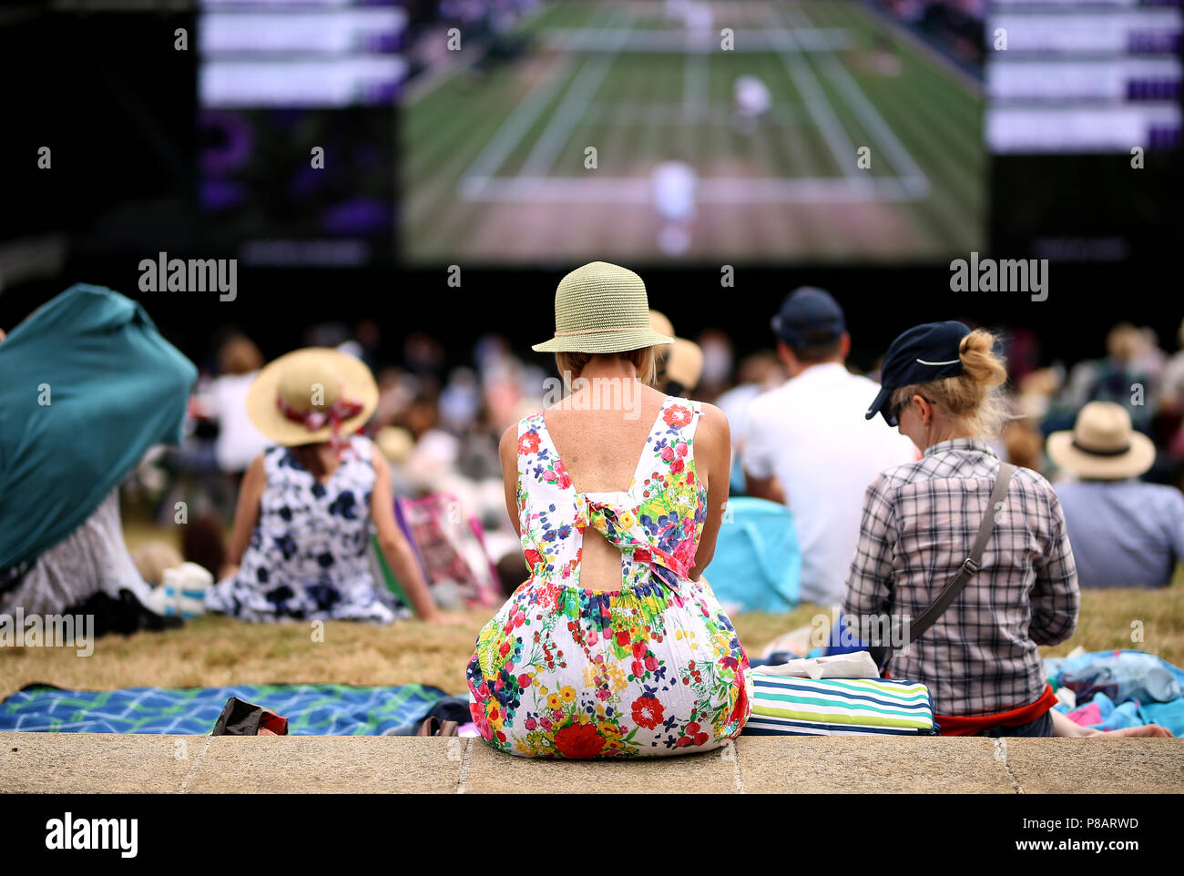 A spectator watches the tennis action on the big screen from Murray ...