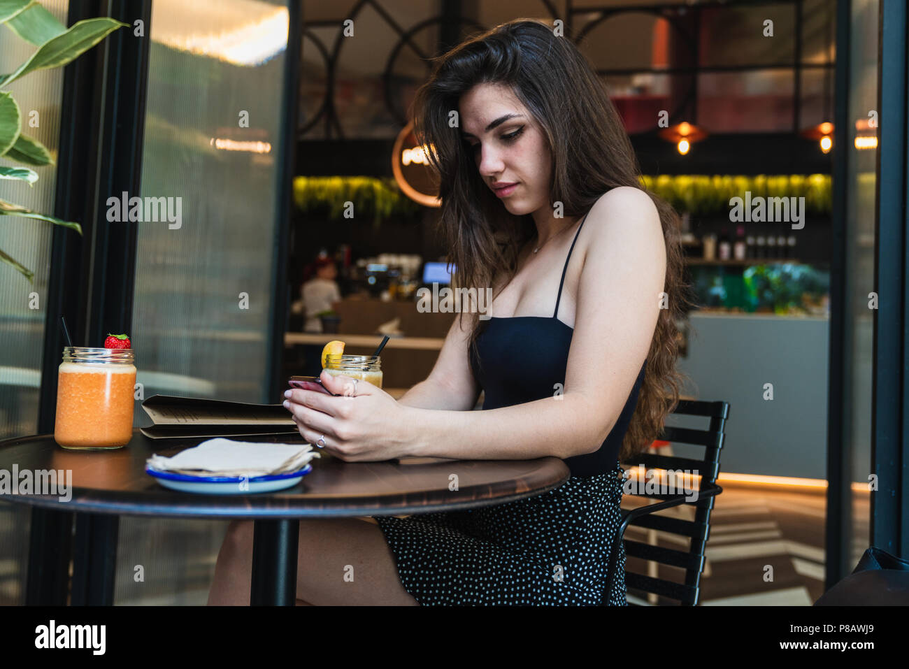 Side view of beautiful young woman in casual outfit using modern ...