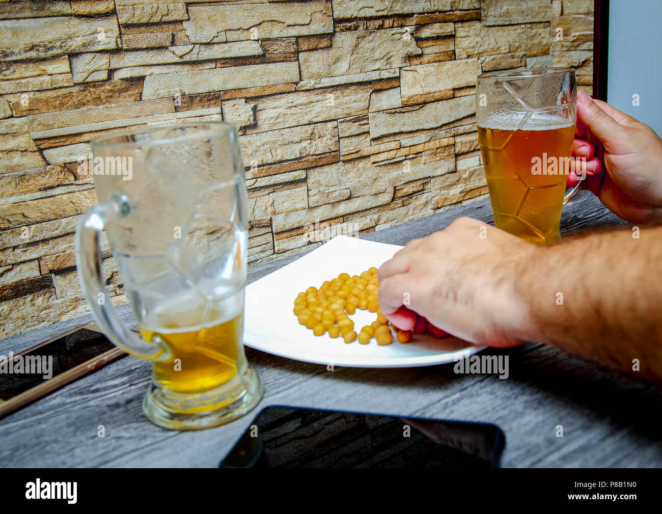 Friends sit in a bar. Men's hands holding a glass of beer Stock Photo ...