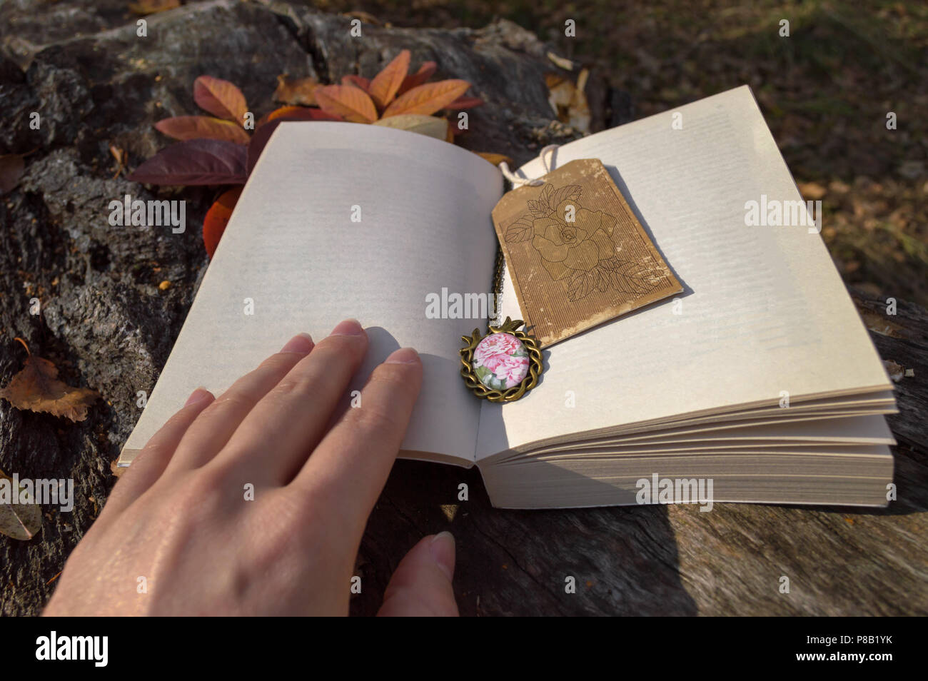 open book with vintage bookmark and female hand Stock Photo - Alamy
