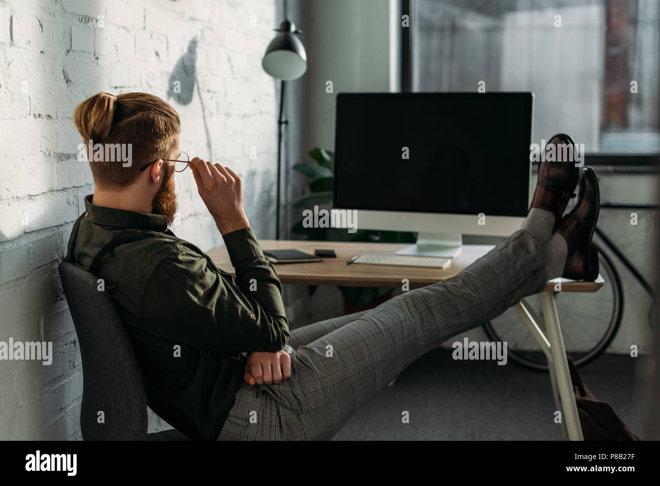 side view of businessman sitting with legs on office table Stock Photo ...