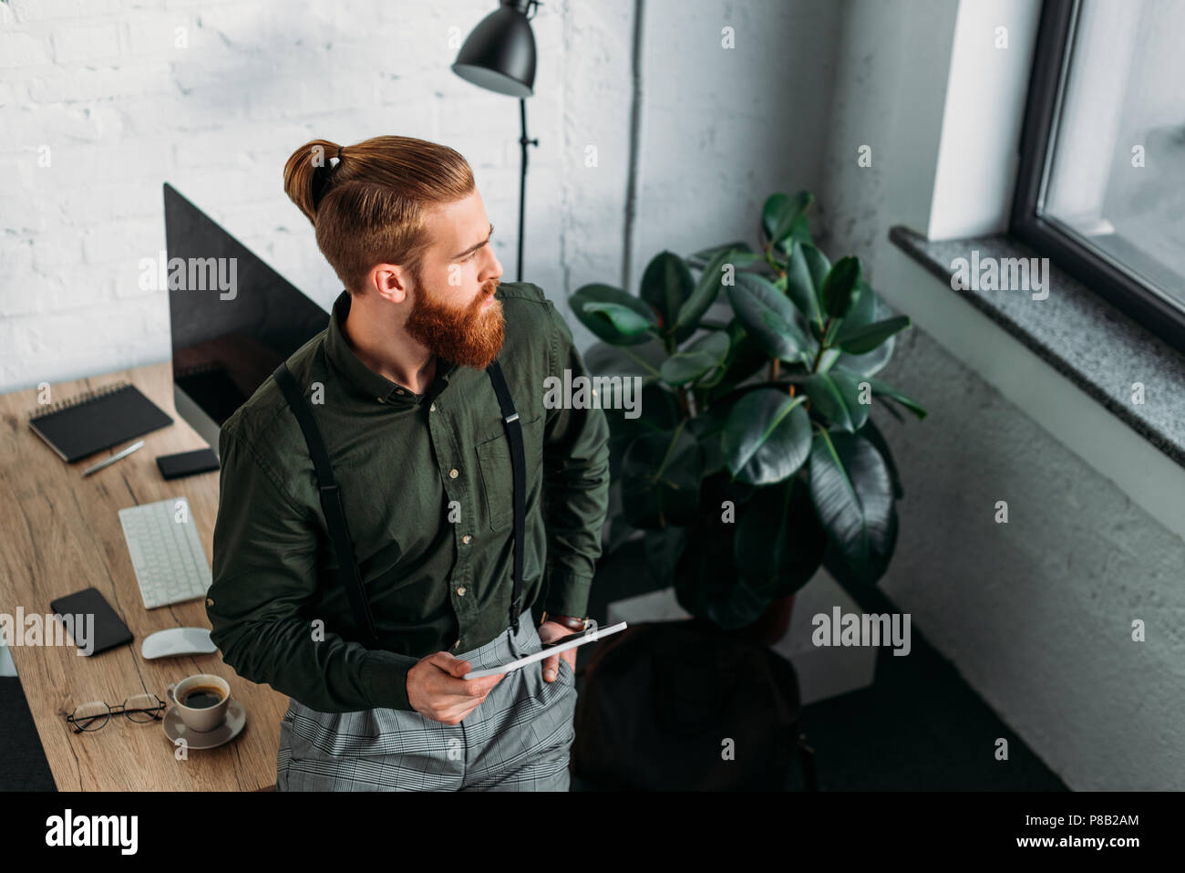 high angle view of businessman holding tablet and looking away Stock ...