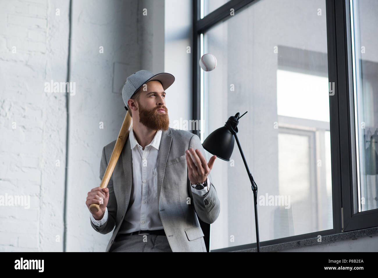 businessman throwing up baseball ball and holding baseball bat Stock ...