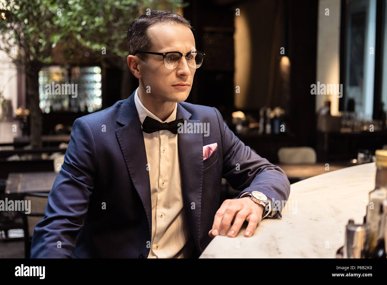 stylish man in stylish suit sitting at bar counter of luxury restaurant ...