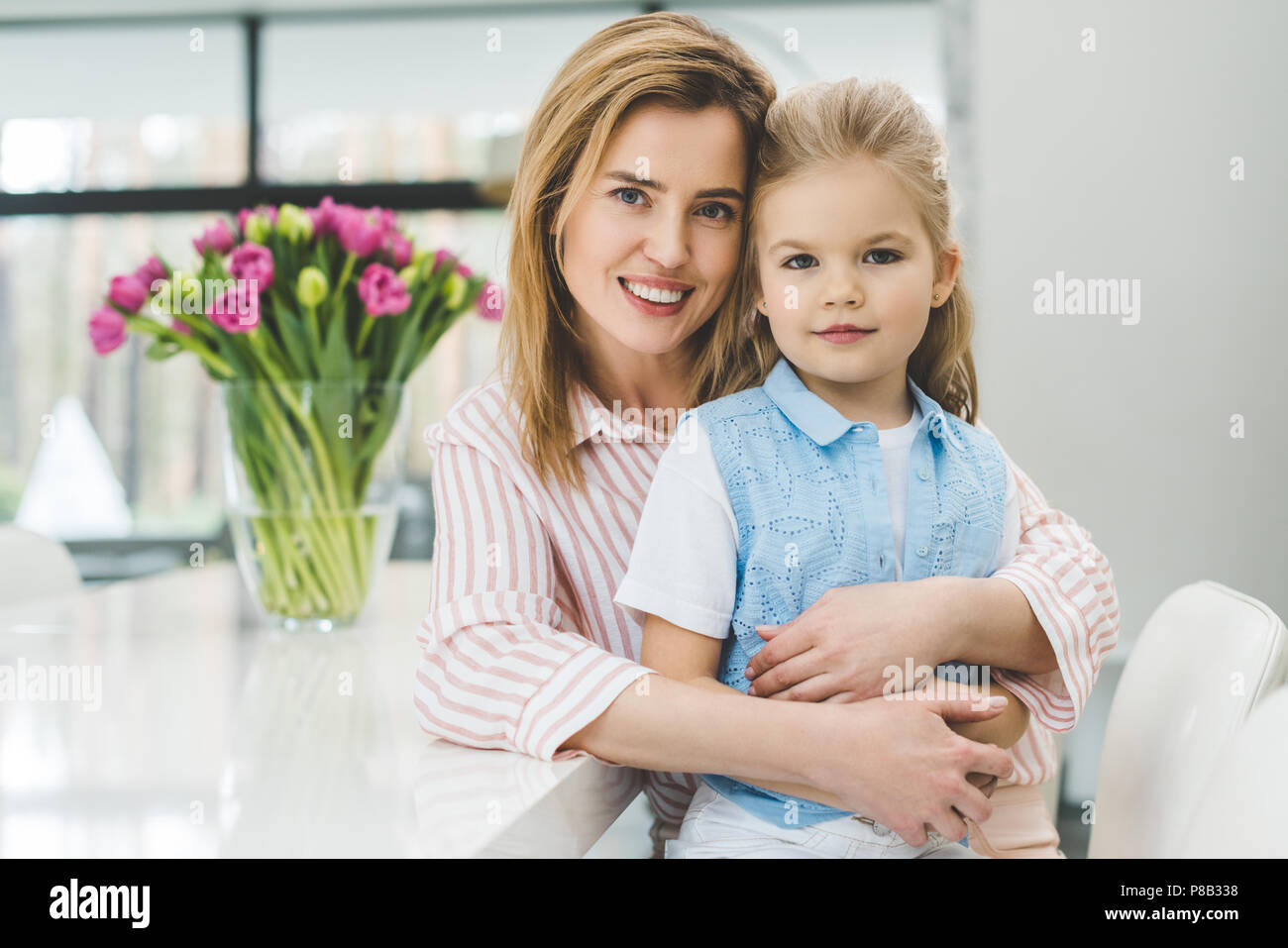 portrait of smiling mother hugging little daughter at home Stock Photo - Alamy