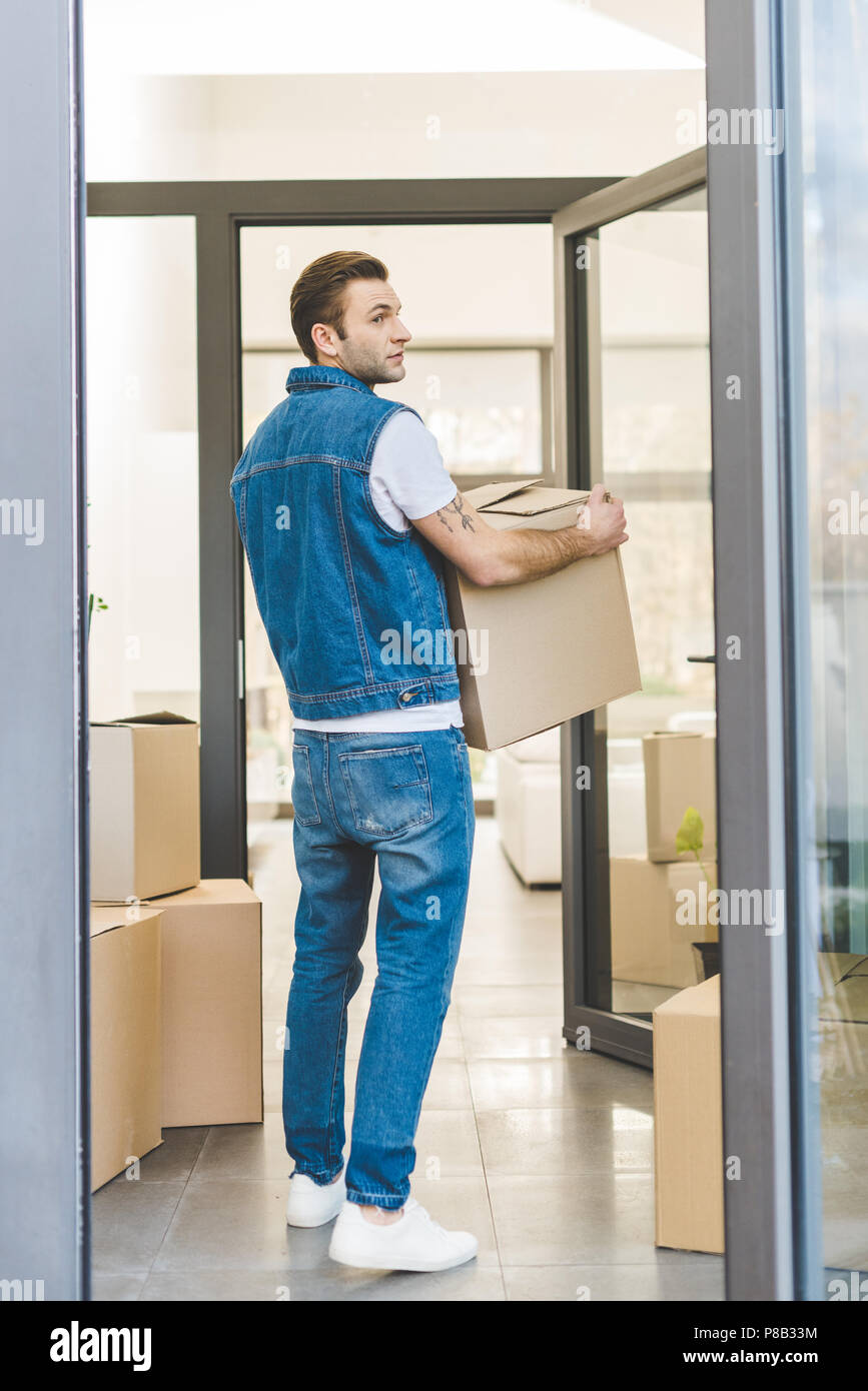 back view of man with cardboard box moving new house Stock Photo - Alamy