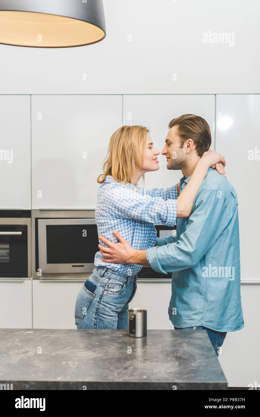side view of affectionate couple hugging each other at home Stock Photo ...