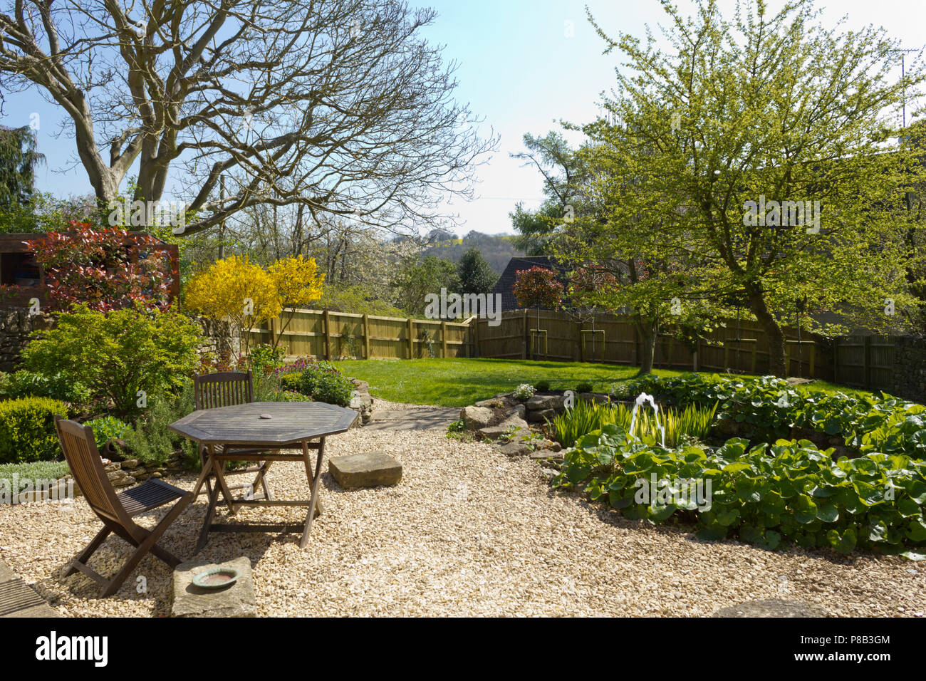 Spring garden with table and chairs on a gravelled patio Stock Photo ...