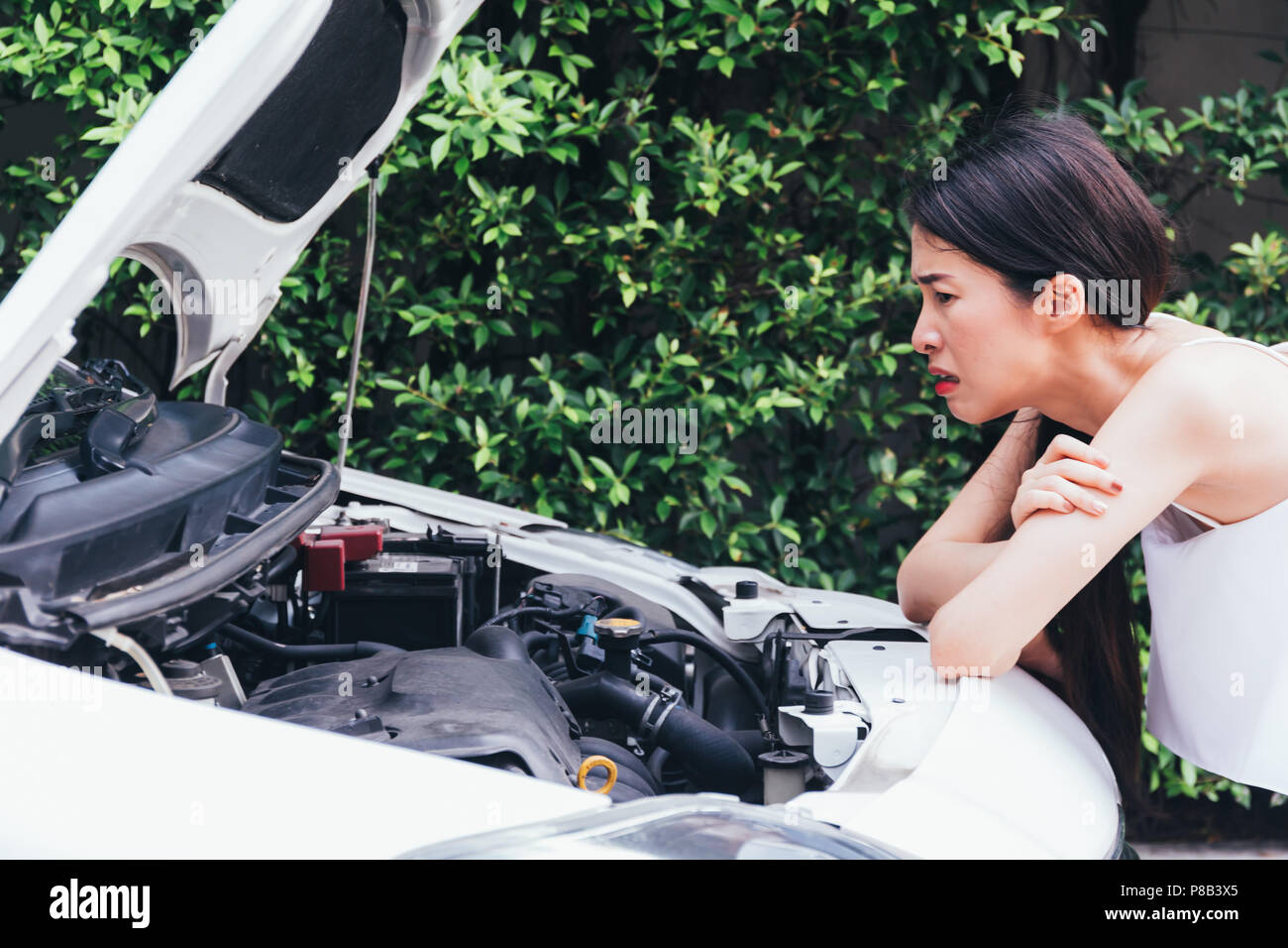 Asian woman frustrated and angry checking her broken car and failed ...