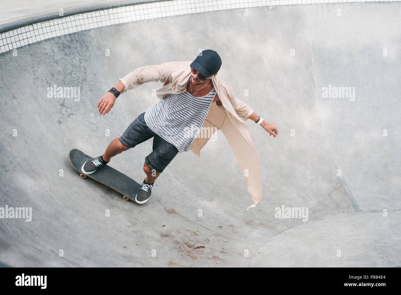 young skater skating on longboard in pool at skatepark Stock Photo - Alamy