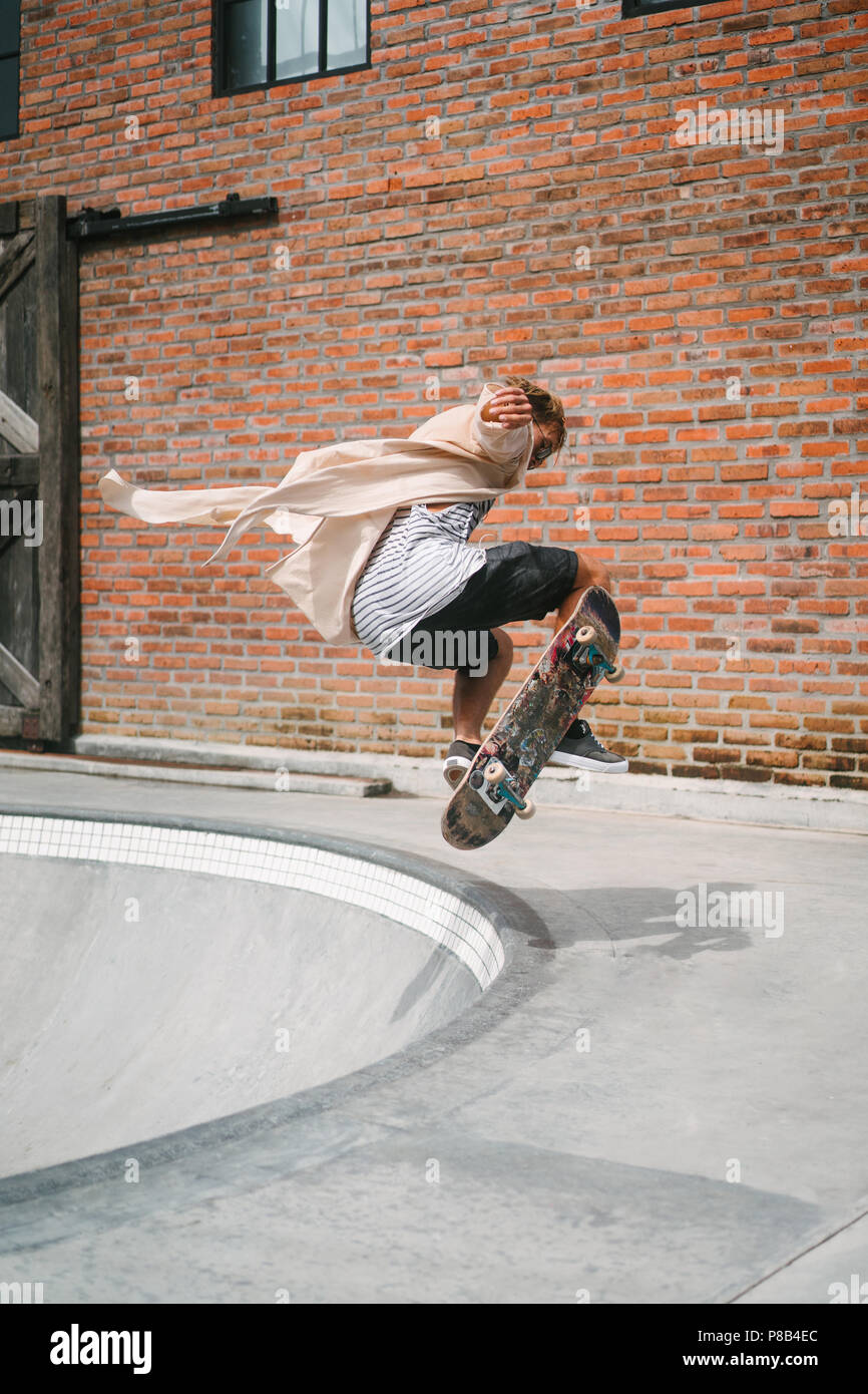 handsome skater jumping from pool in skatepark Stock Photo - Alamy