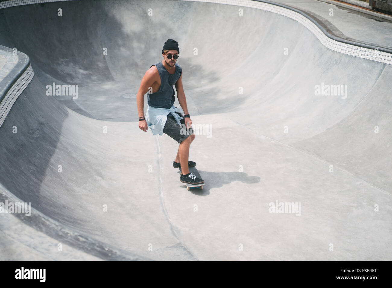 handsome skater skating in pool at skatepark Stock Photo - Alamy