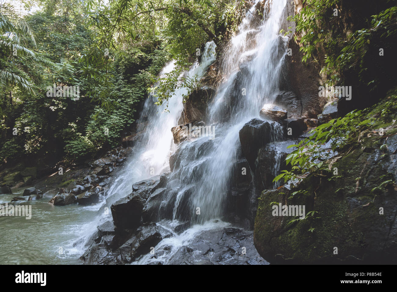 scenic view of beautiful Kanto Lampo Waterfall, green plants and rocks ...