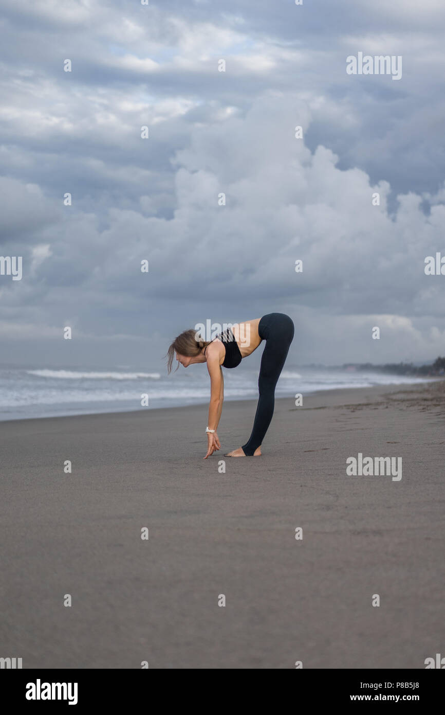 side view of young woman practicing yoga in Halfway Lift pose (Ardha ...