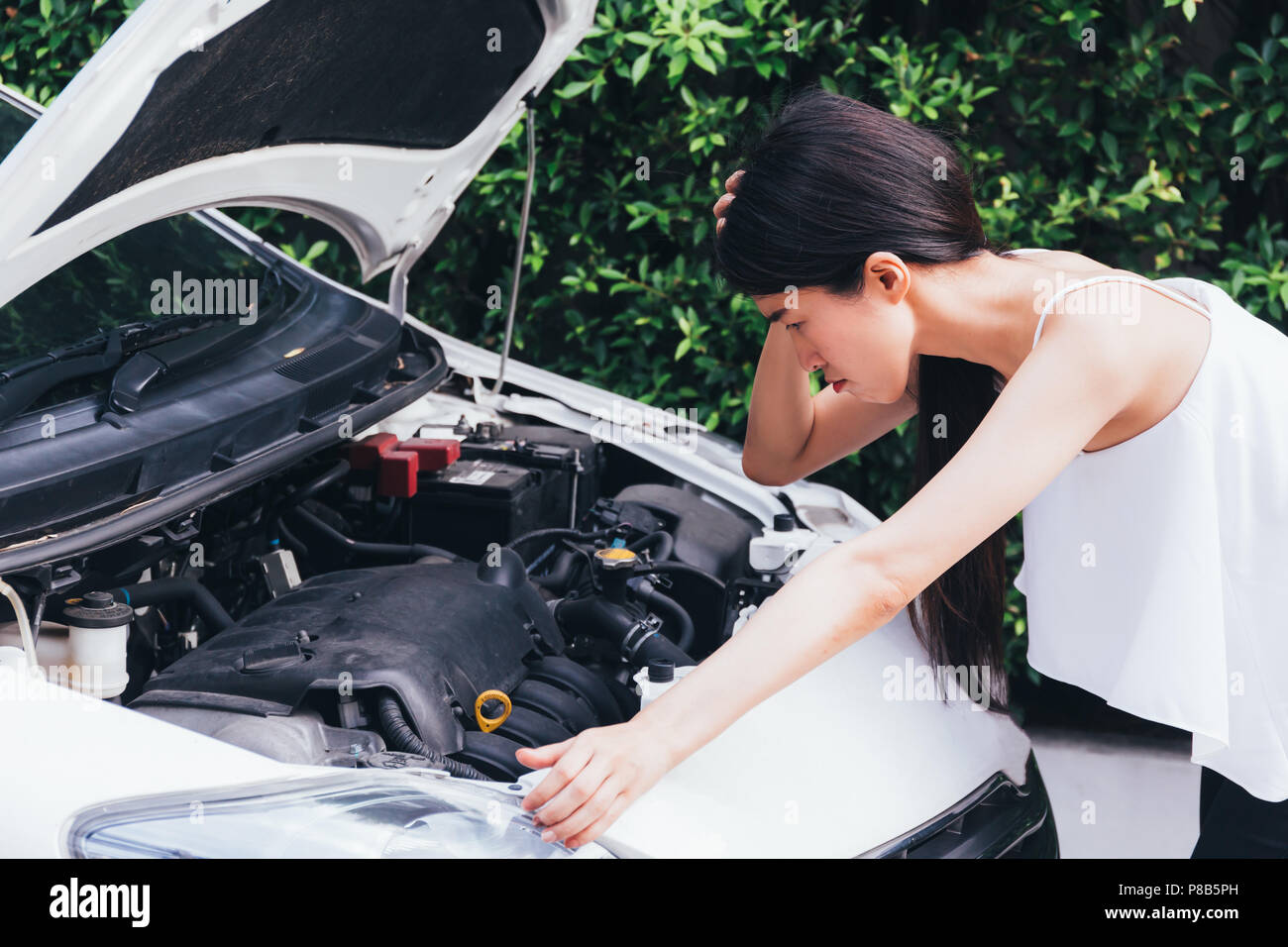 Asian woman frustrated and angry checking her broken car and failed ...
