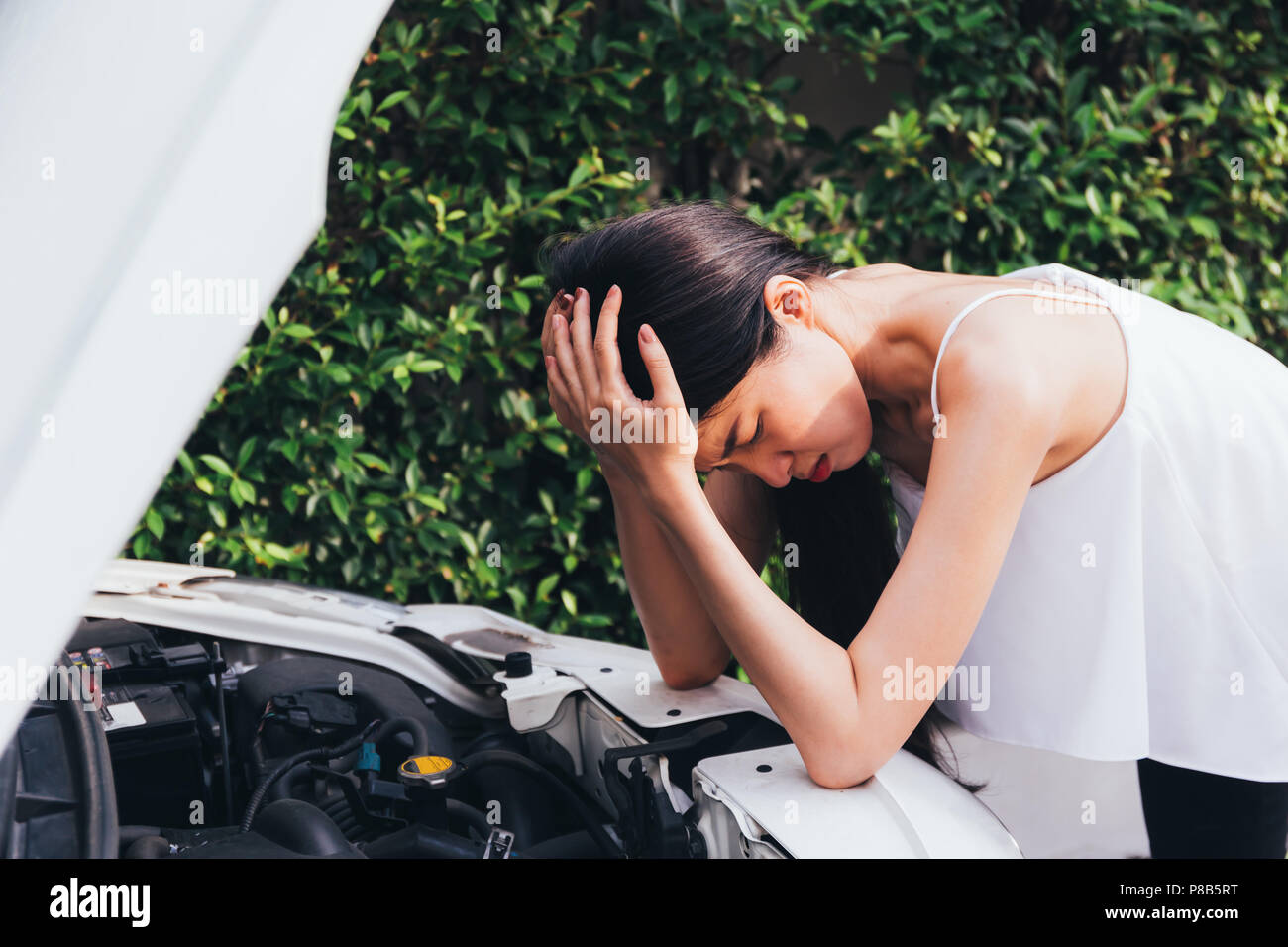 Asian woman frustrated and angry checking her broken car and failed ...