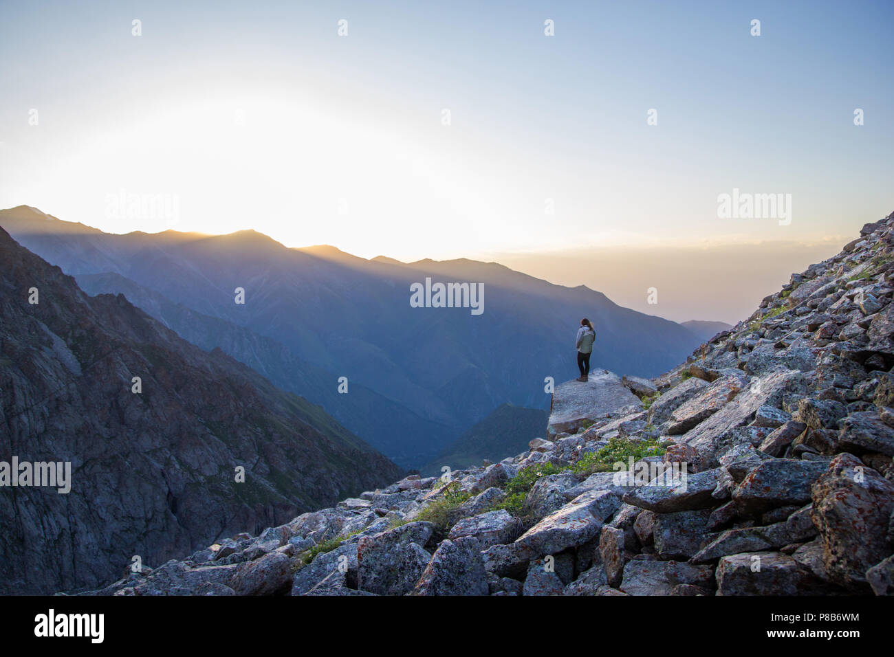 back view of person looking at rocks and beautiful mountains at foggy ...