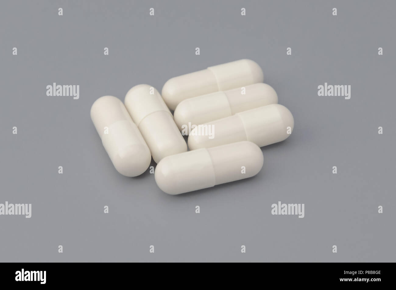 Six white tablets on a gray background Stock Photo - Alamy