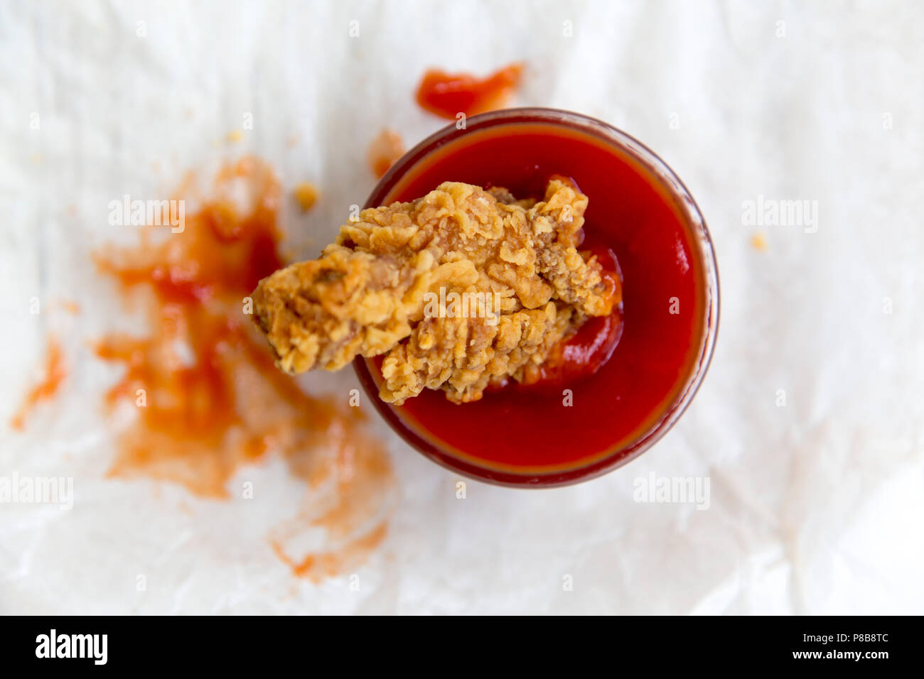 Fried chicken wing in a bowl of sauce, top view. From above Stock Photo ...