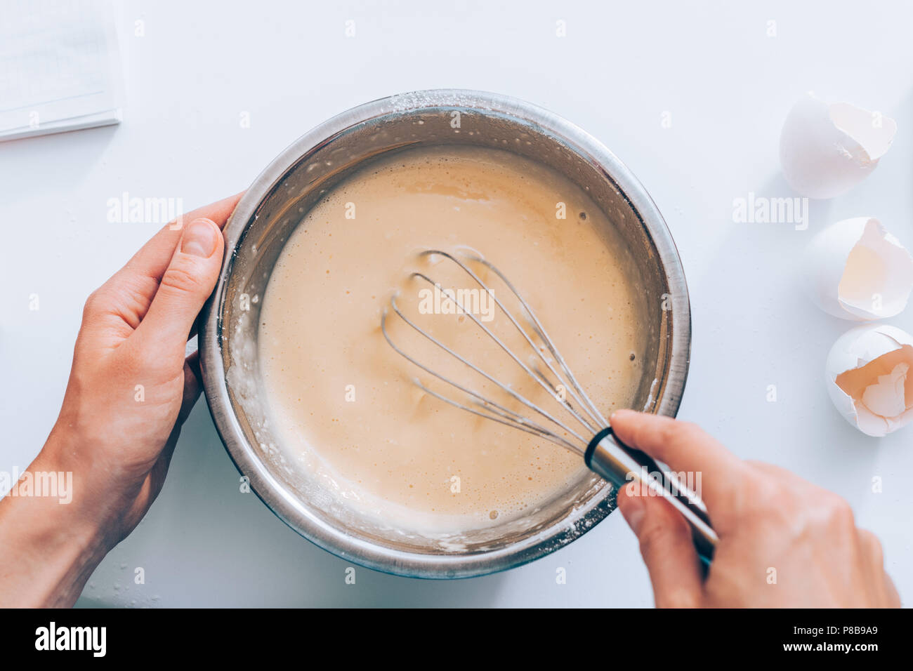 Woman mixing batter, top view. Female's hands holding bowl whisking ...