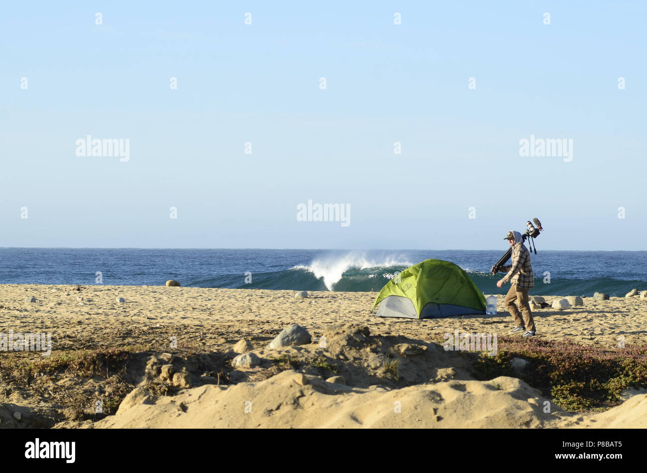 cameraman on beach with video camera on tripod Stock Photo - Alamy